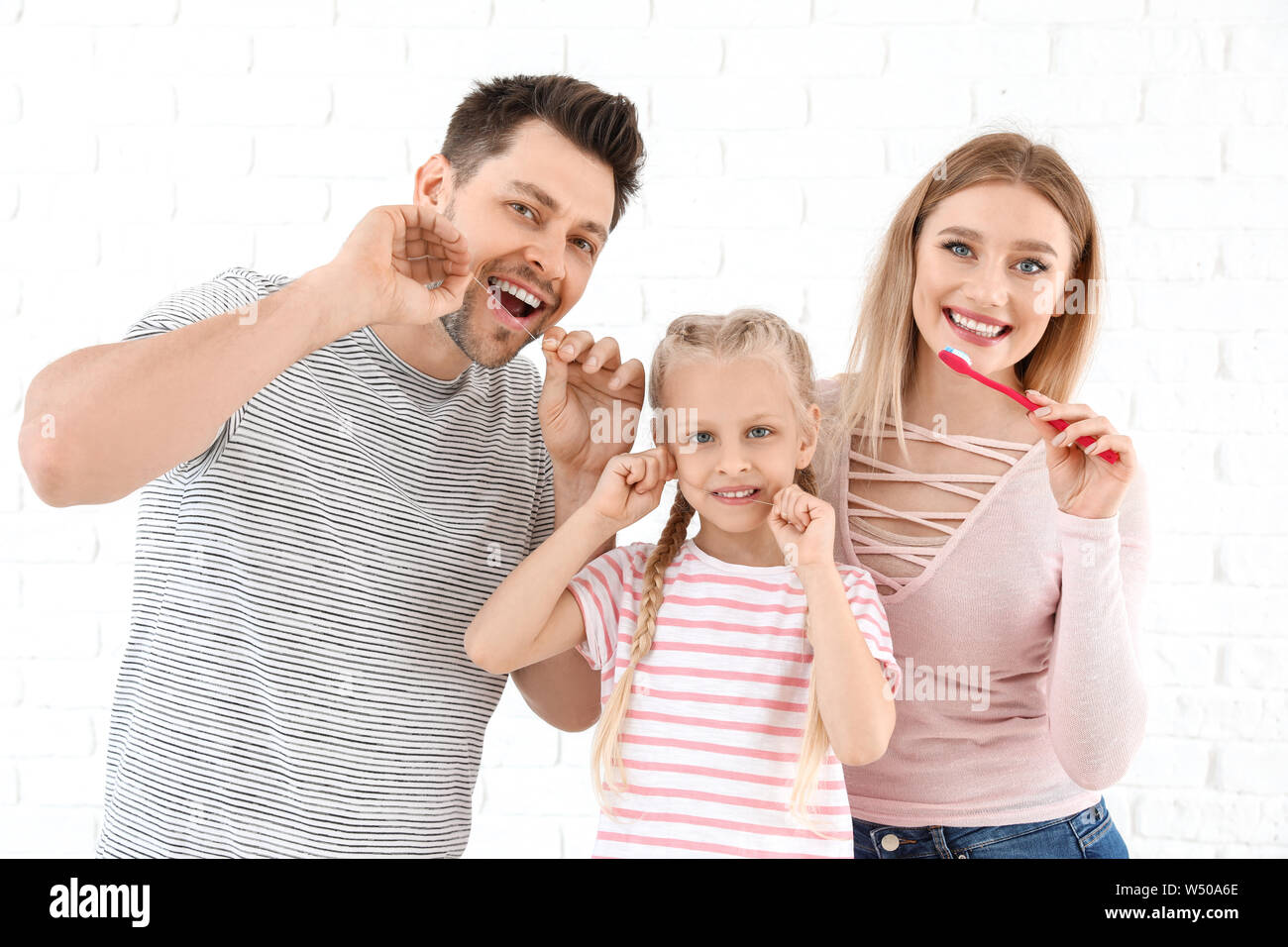 Family cleaning teeth on white background Stock Photo - Alamy