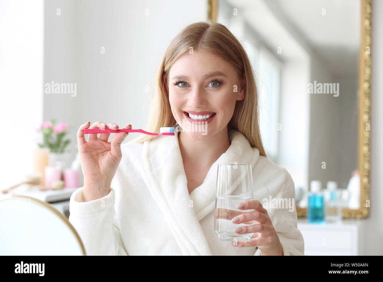 Beautiful woman cleaning teeth at home Stock Photo - Alamy