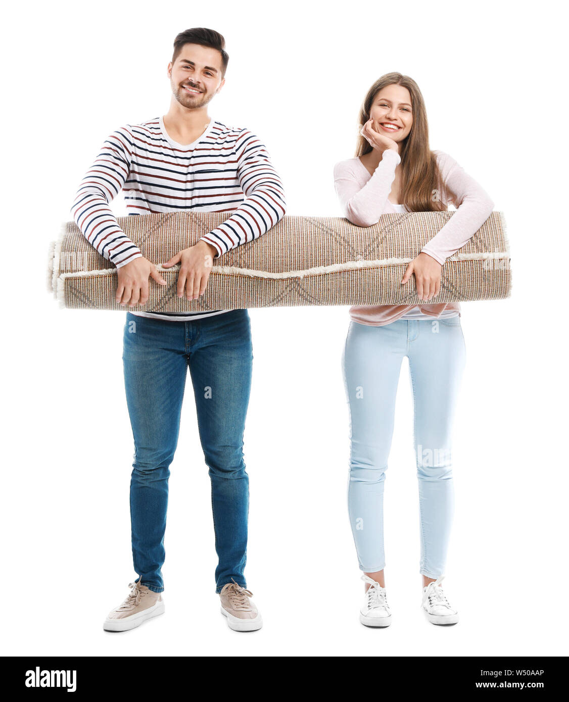 Young couple holding rolled carpet against white background Stock Photo ...