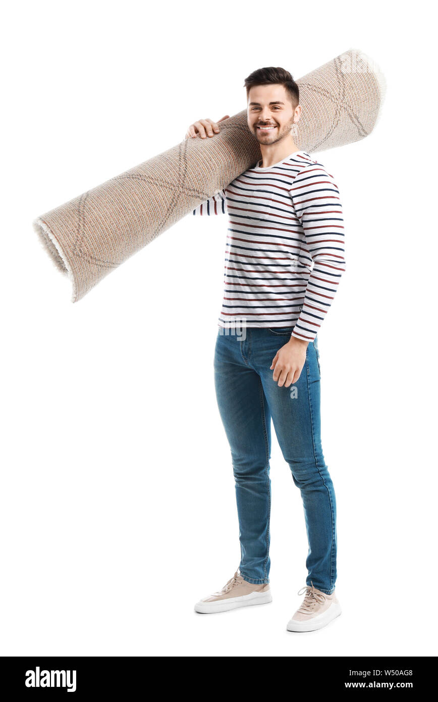 Young man holding rolled carpet against white background Stock Photo ...
