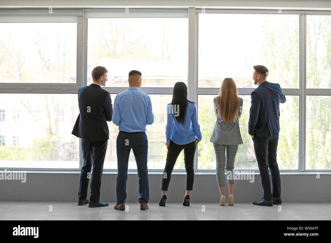 Team of business people near window in office, back view Stock Photo ...