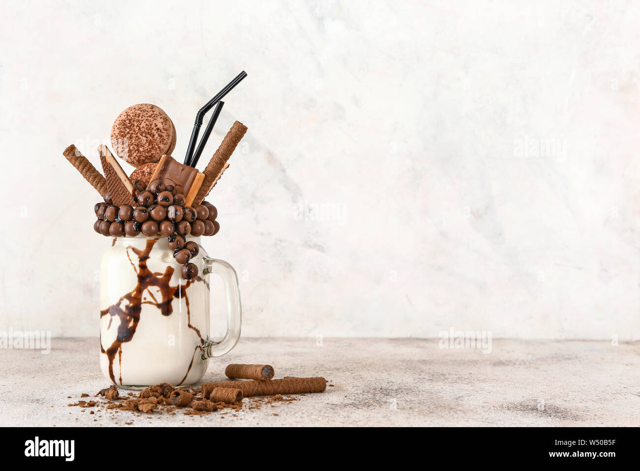 Mason jar with delicious freak shake on light background Stock Photo ...