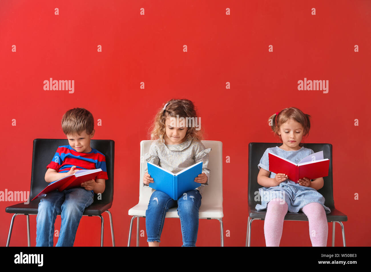 Cute little children reading books on color background Stock Photo - Alamy