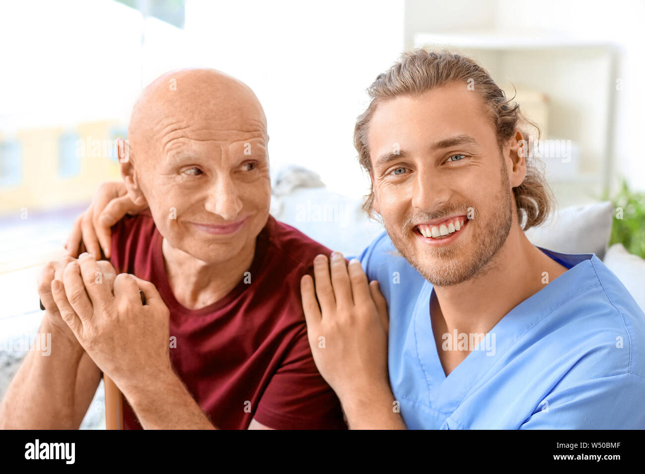 Elderly man with caregiver in nursing home Stock Photo - Alamy