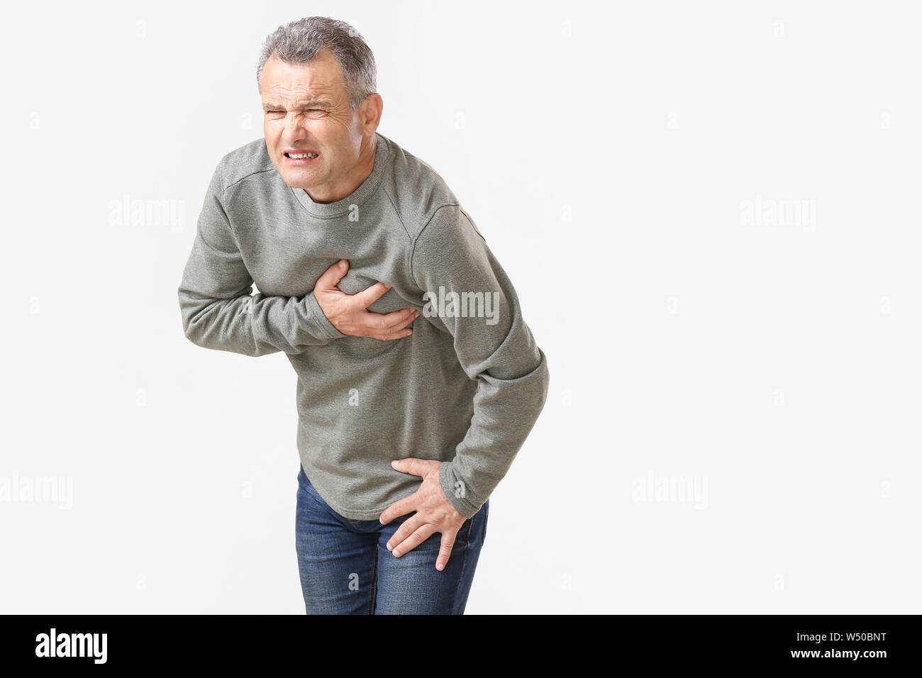 Mature man suffering from heart attack on white background Stock Photo ...