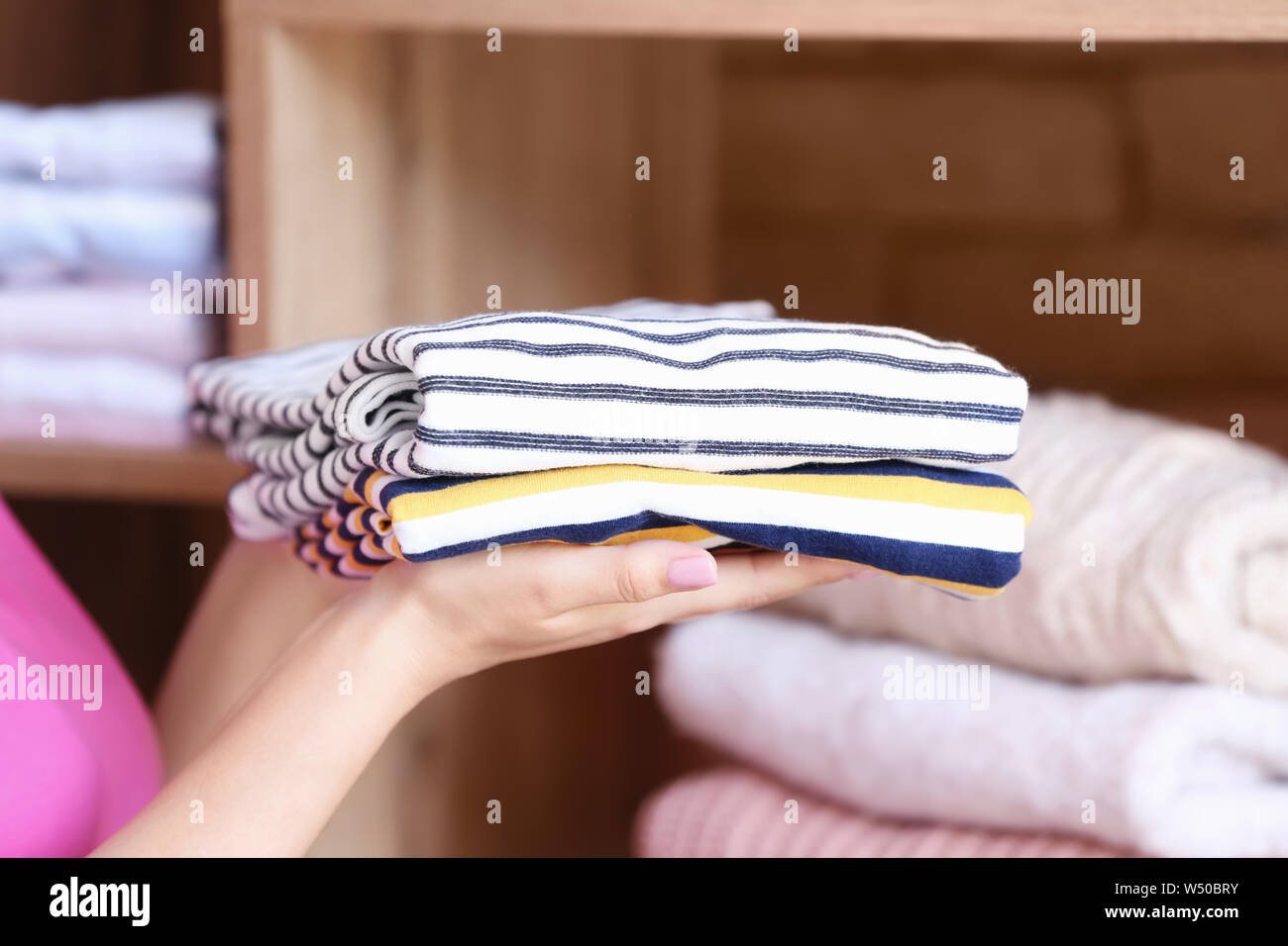 Woman with stack of clean clothes at home Stock Photo - Alamy