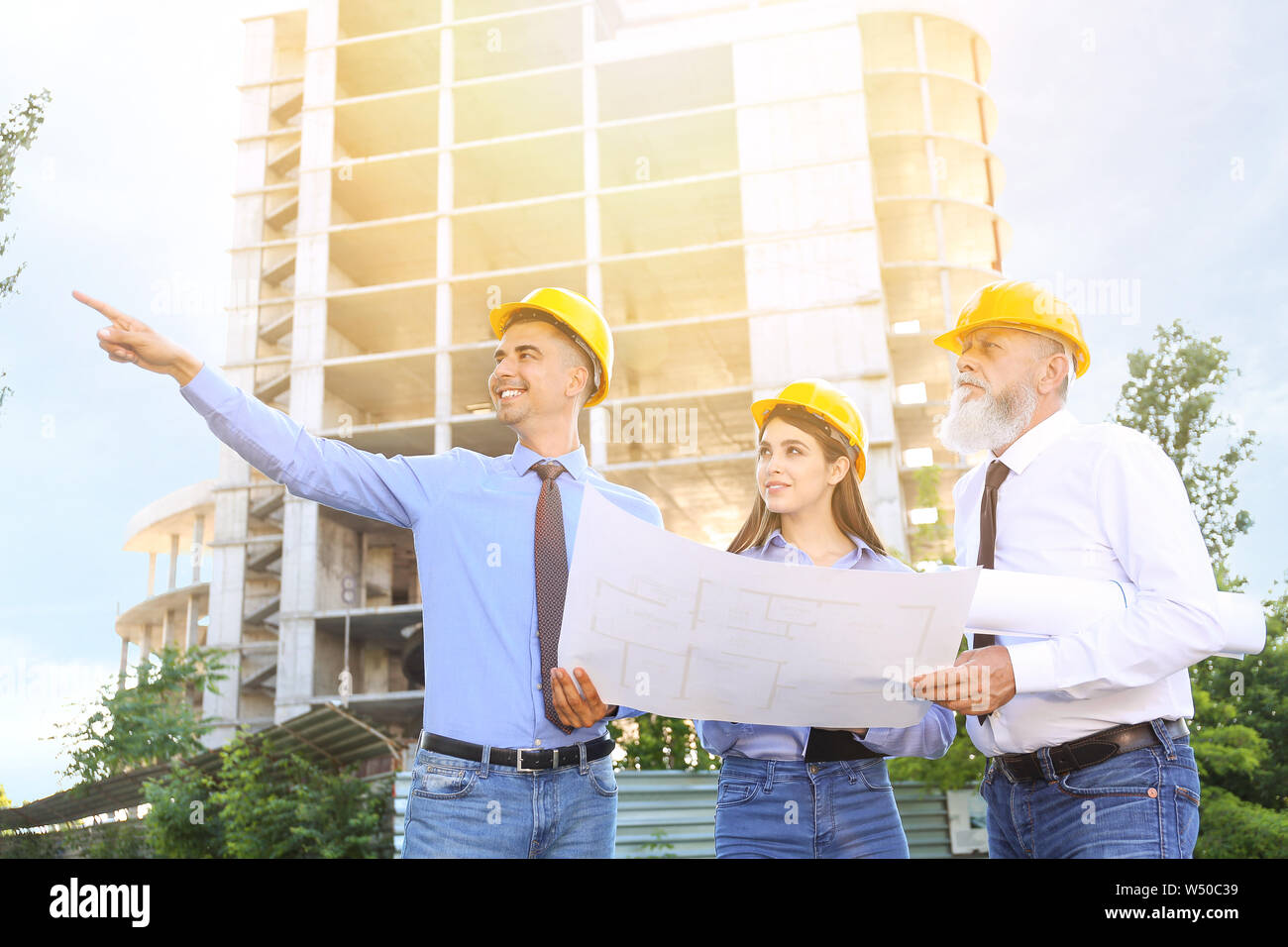 Architects discussing project of building outdoors Stock Photo - Alamy