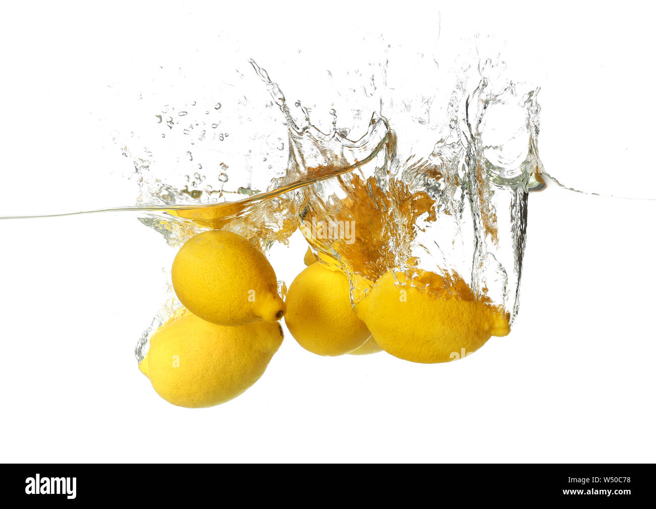 Falling of lemons into water on white background Stock Photo - Alamy