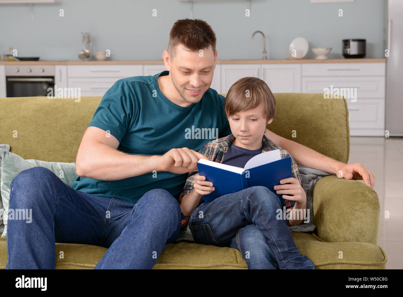 Father and his little son reading book at home Stock Photo - Alamy