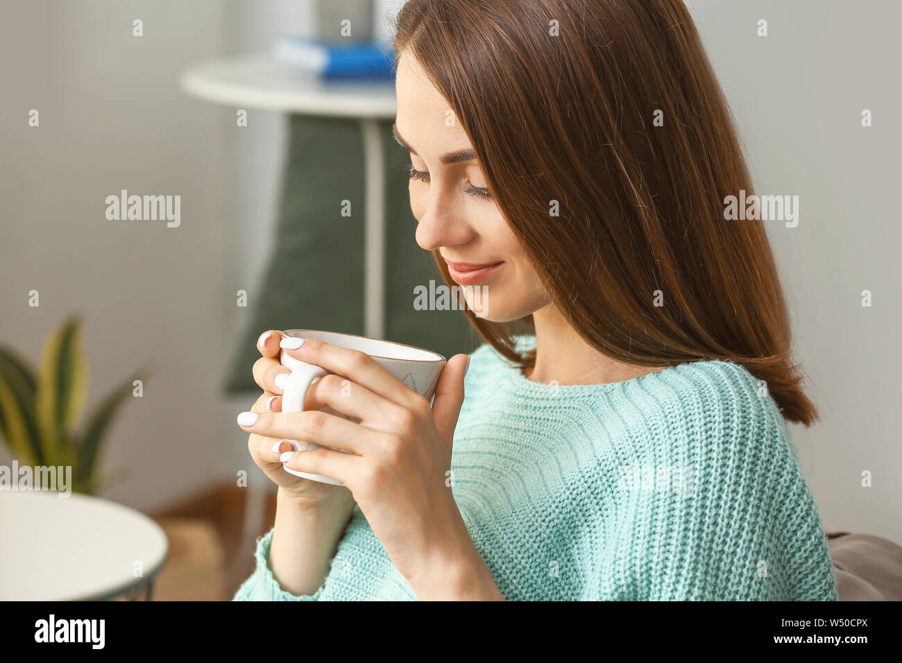 Beautiful young woman drinking tea at home Stock Photo - Alamy