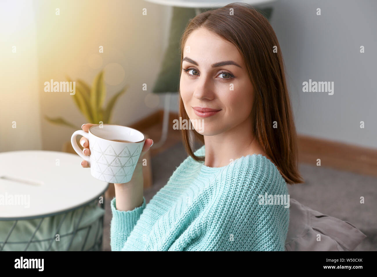 Beautiful young woman drinking tea at home Stock Photo - Alamy