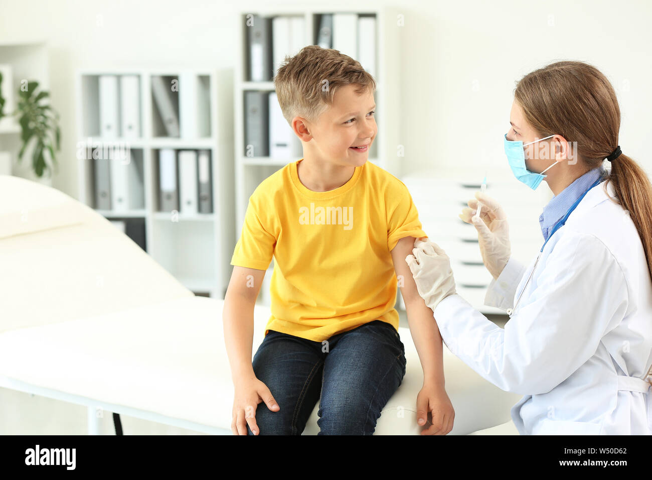 Doctor vaccinating little boy in clinic Stock Photo - Alamy
