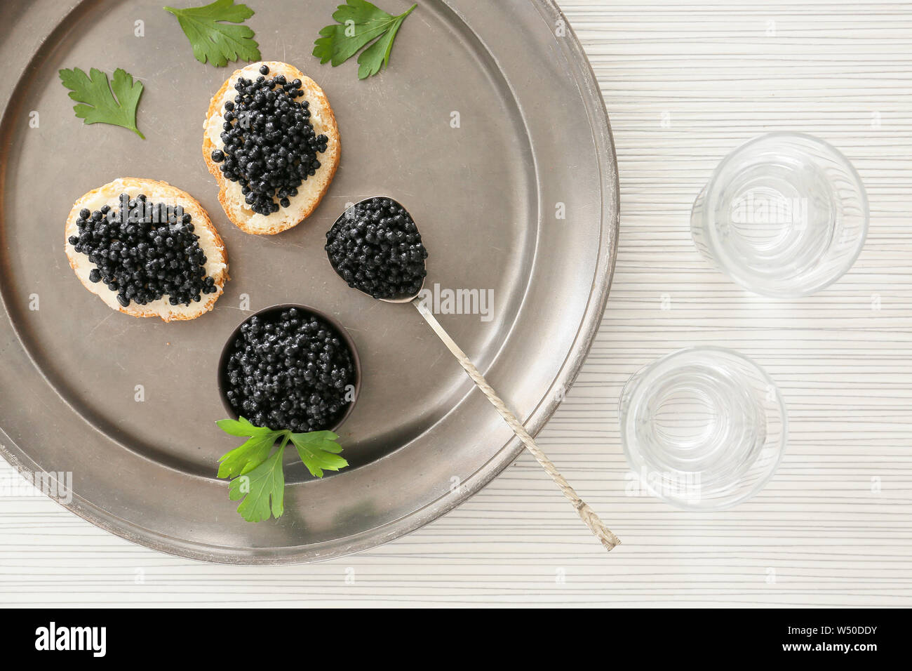 Tray with delicious caviar and glasses of vodka on white table Stock ...