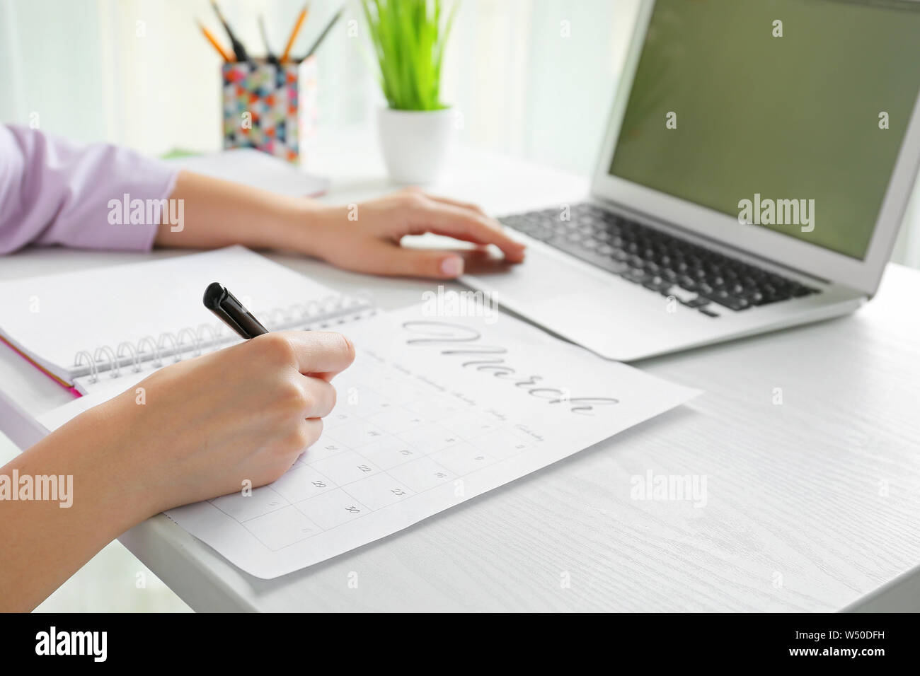 Young woman marking date in calendar at table, closeup Stock Photo - Alamy
