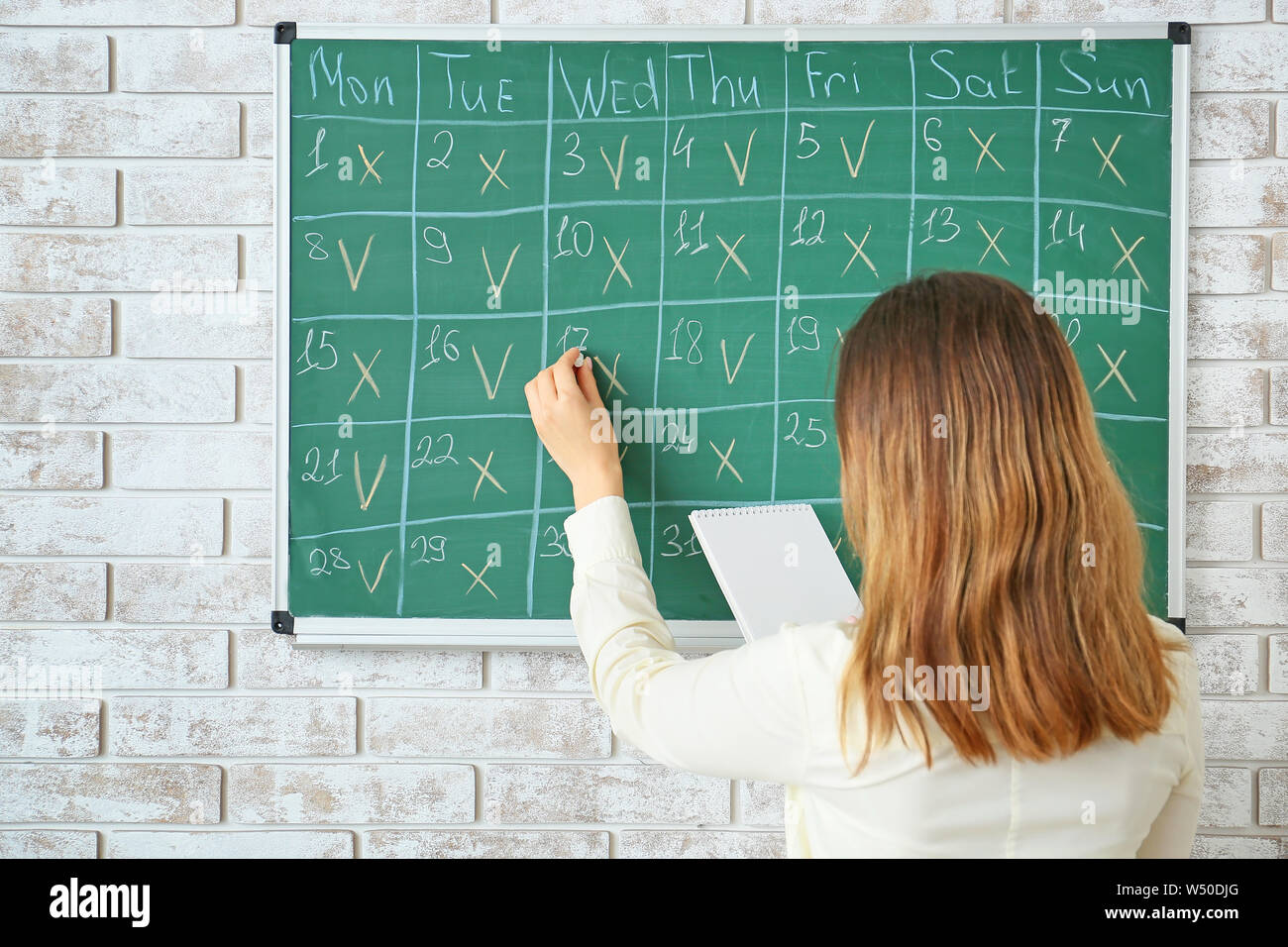 Office worker marking date on blackboard with drawn calendar Stock ...