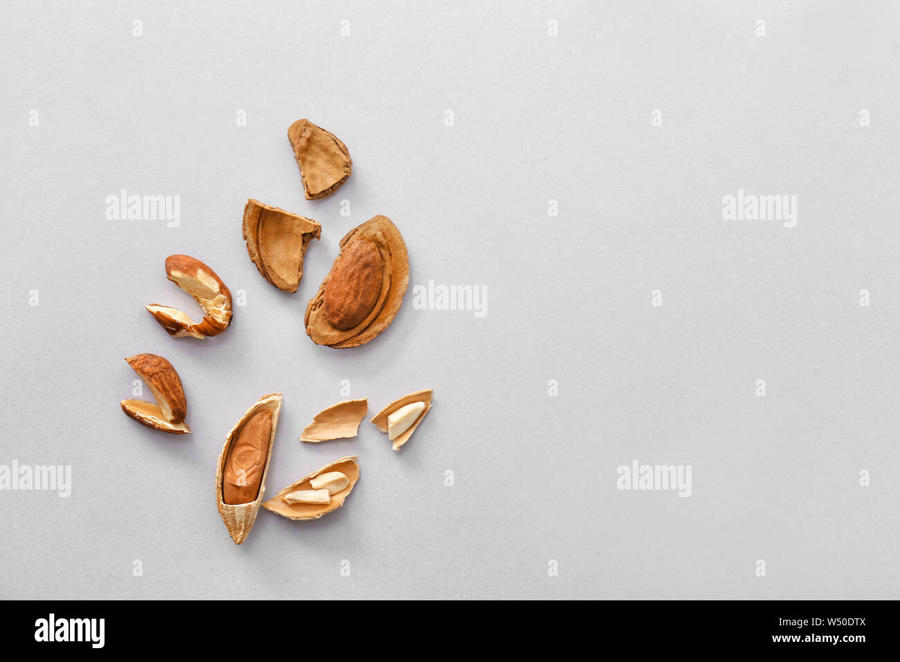 Cracked almonds on light background Stock Photo - Alamy