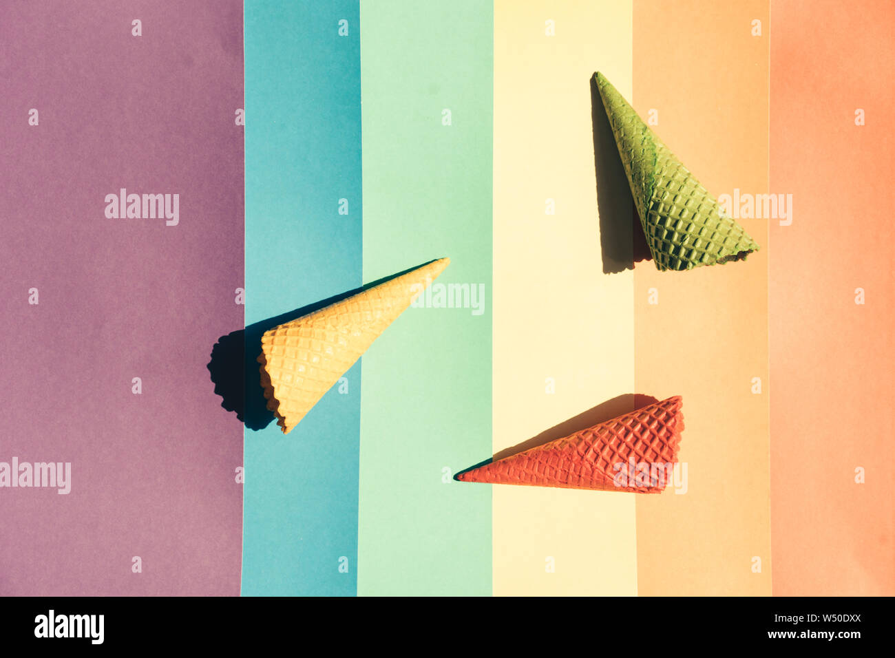 Three wafer cones on a rainbow paper striped background. Layout on a ...