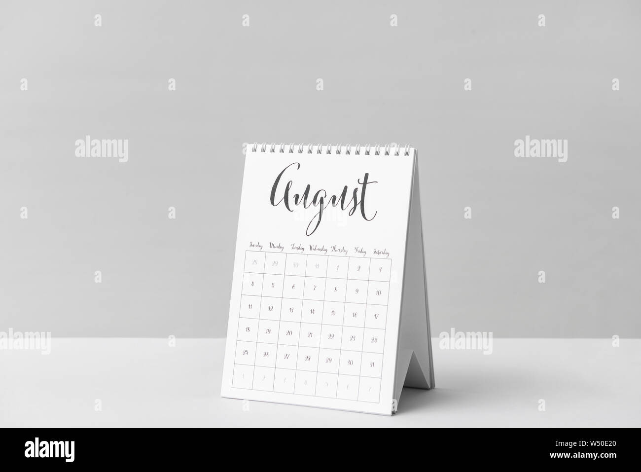 Flip calendar on table against light background Stock Photo - Alamy