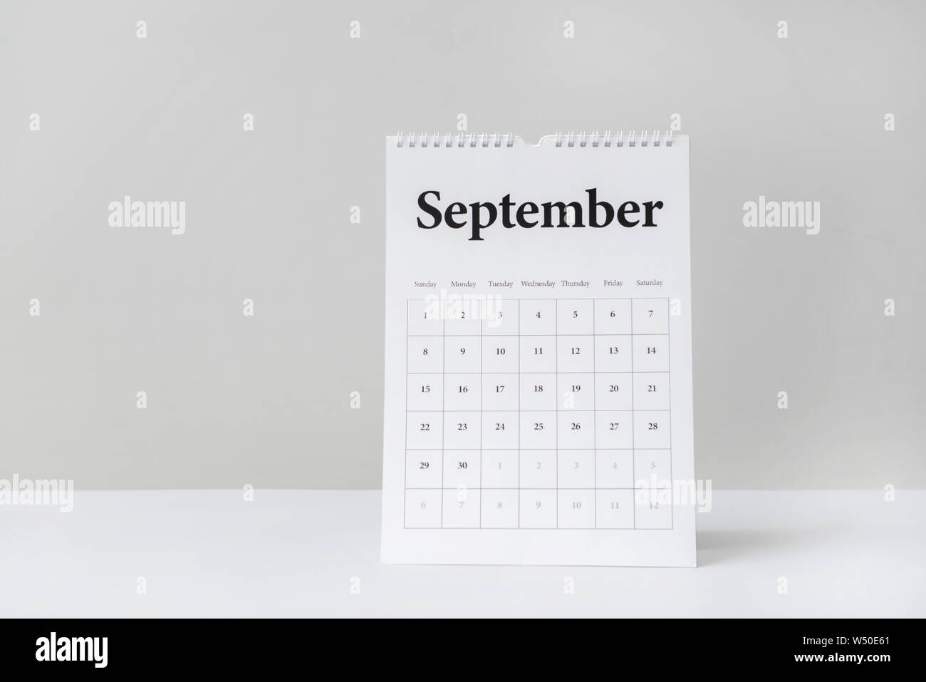 Flip calendar on table against light background Stock Photo - Alamy