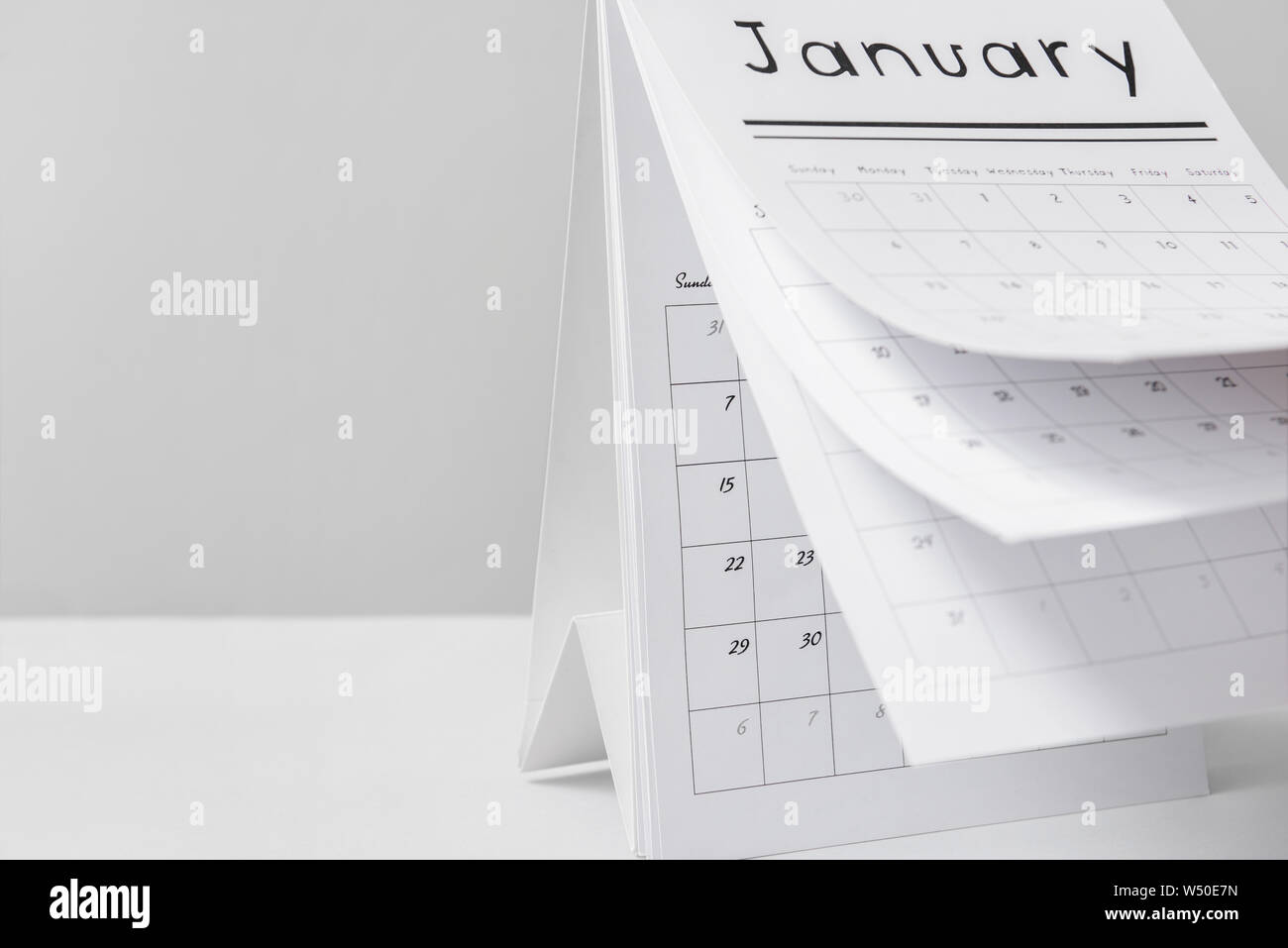 Flip calendar on table against light background Stock Photo - Alamy