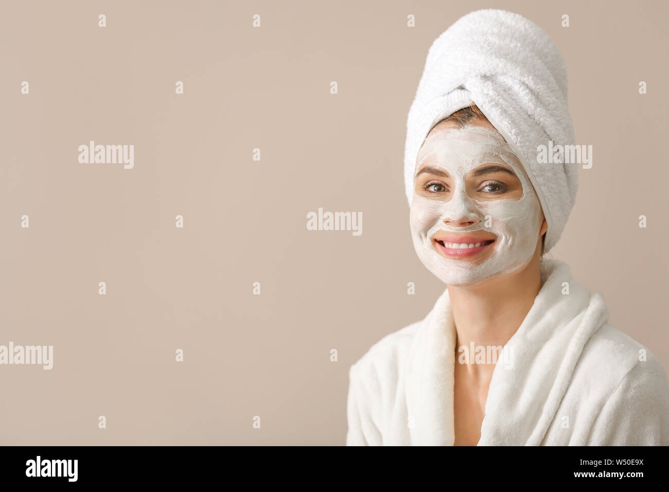 Portrait of woman after shower with mask on face on color background ...