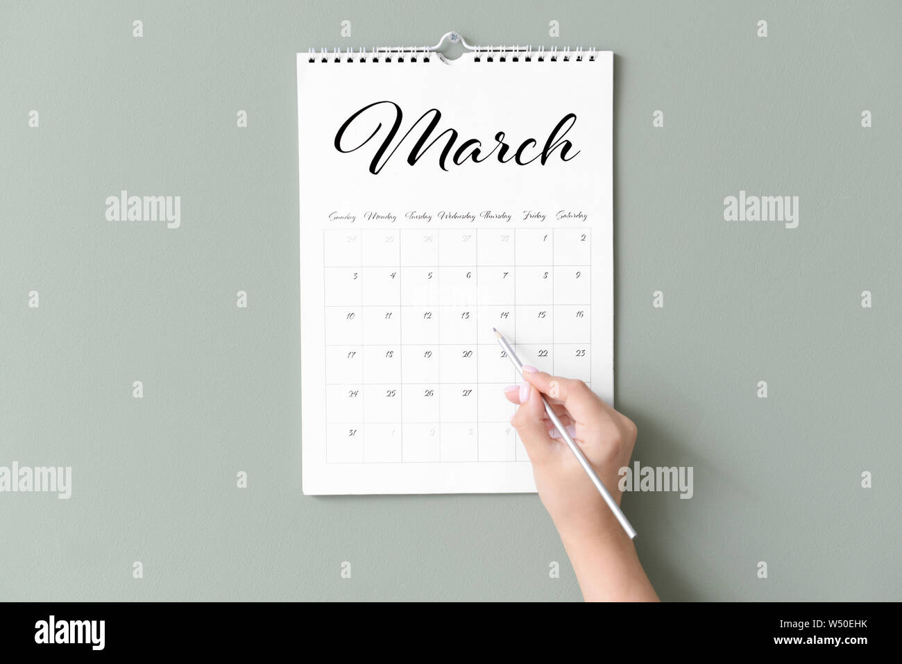 Woman marking date in calendar on color background Stock Photo - Alamy