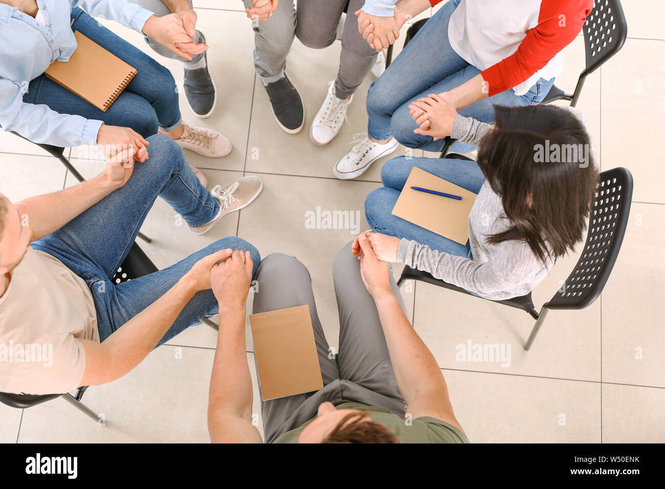 People holding hands at group therapy session Stock Photo - Alamy