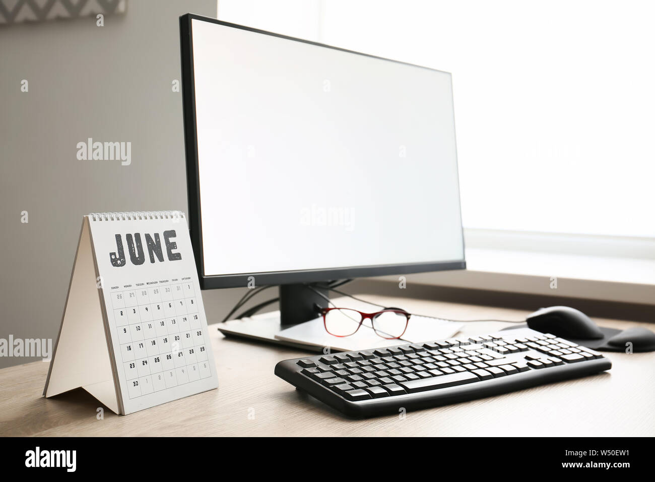 Flip calendar with computer on table in room Stock Photo - Alamy