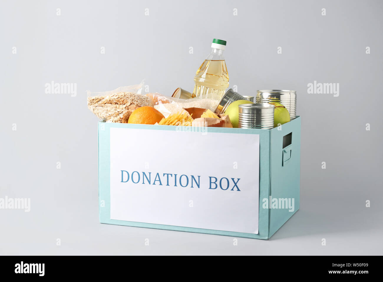 Box with donation food on grey background Stock Photo - Alamy