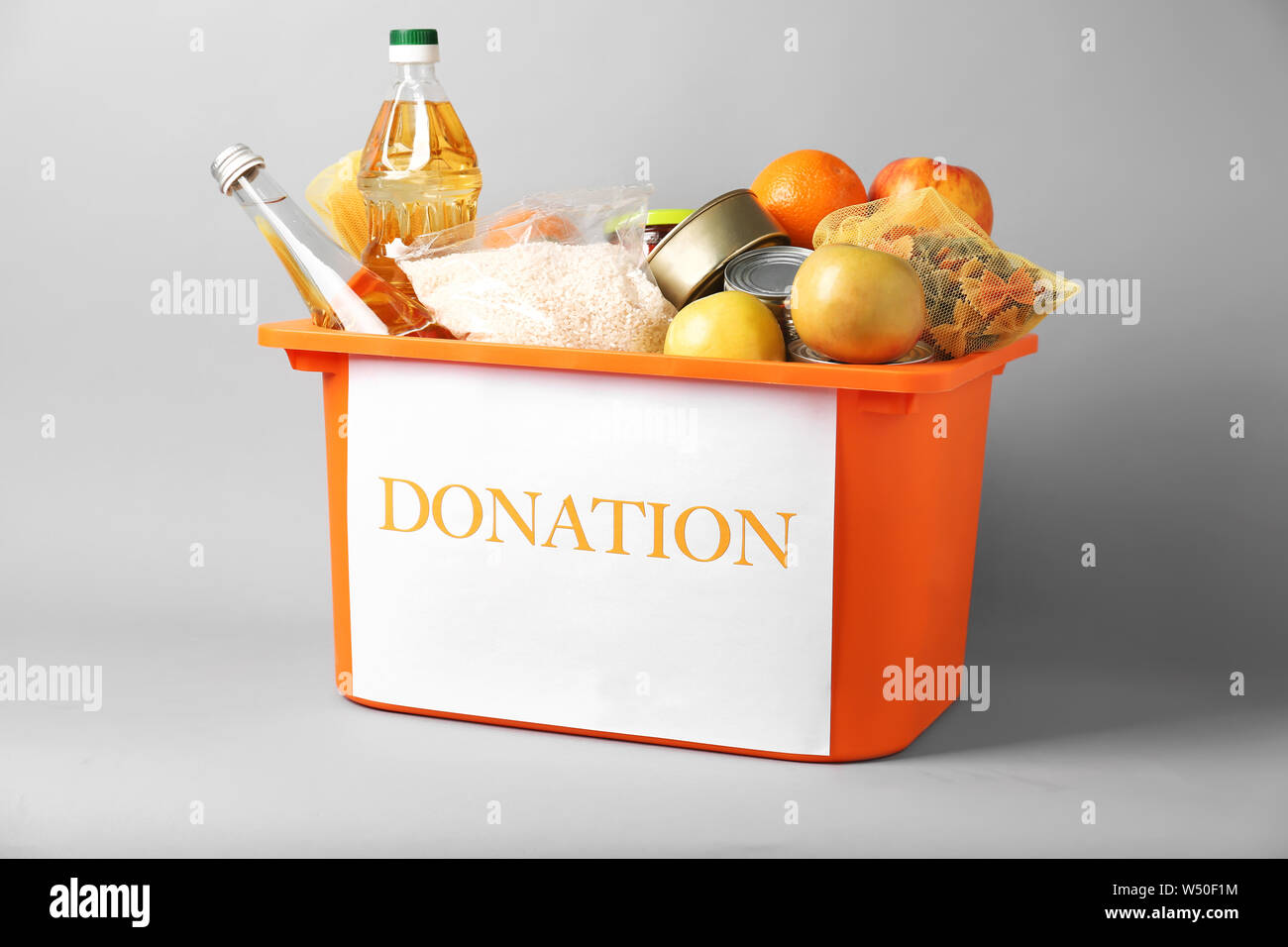 Box with donation food on grey background Stock Photo - Alamy