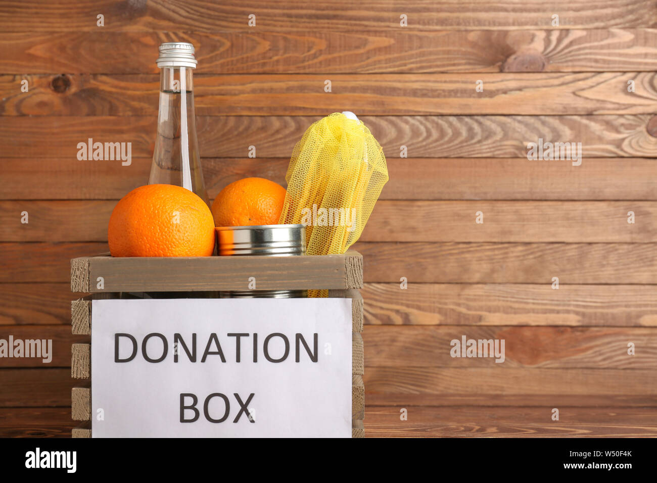 Box with donation food on wooden background Stock Photo - Alamy