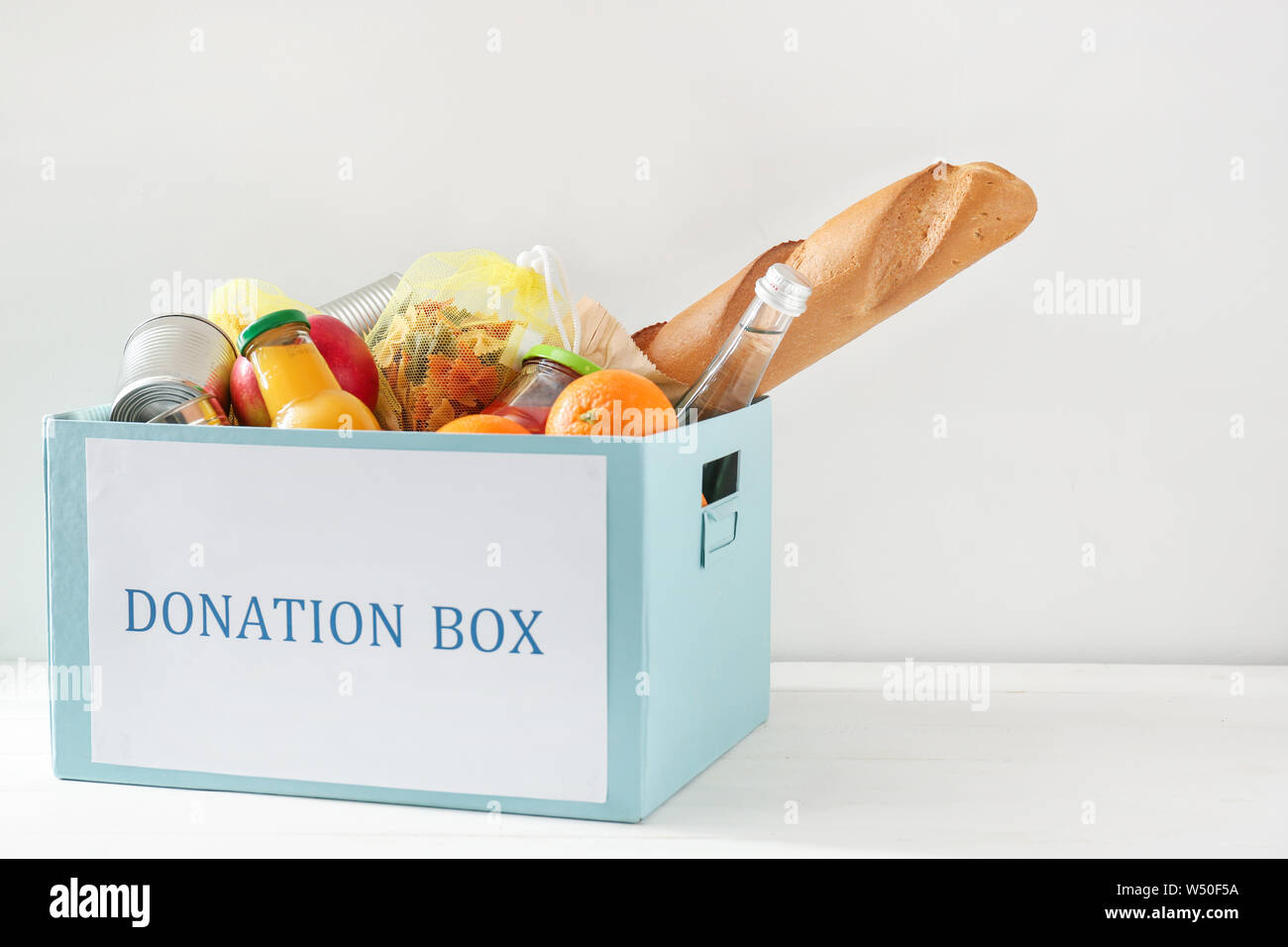 Box with donation food on white background Stock Photo - Alamy