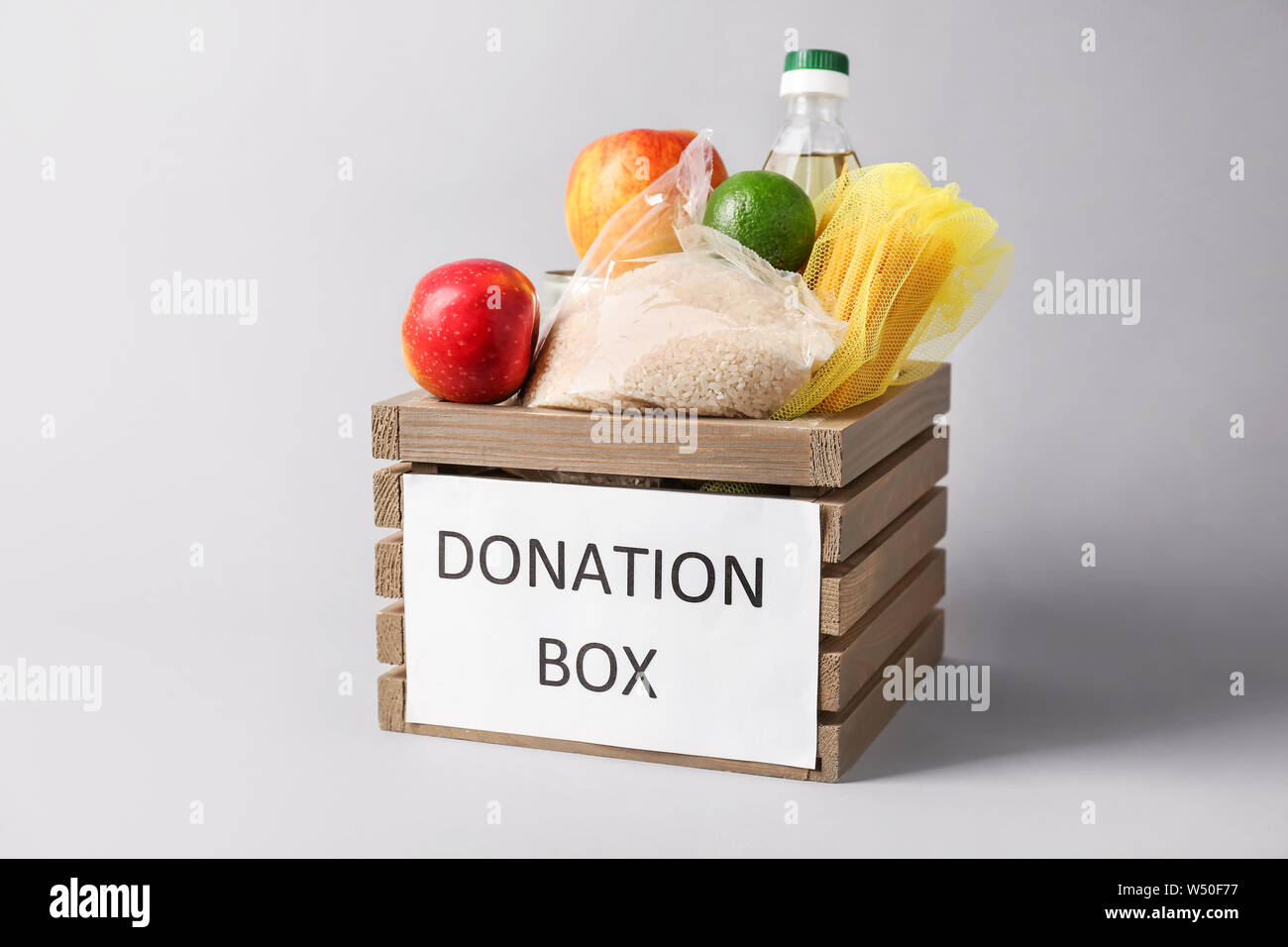 Box with donation food on grey background Stock Photo - Alamy