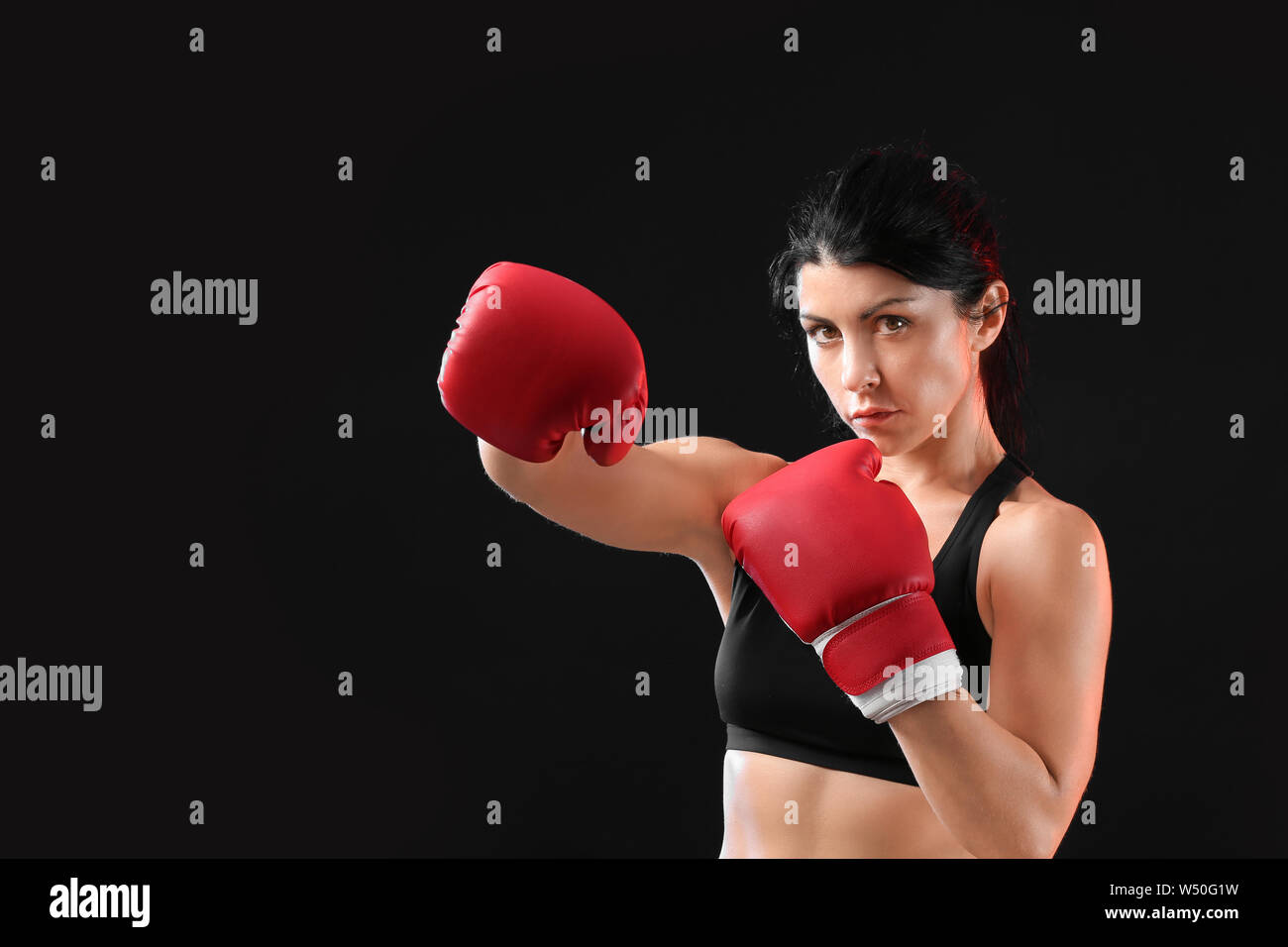 Sporty female boxer on dark background Stock Photo - Alamy