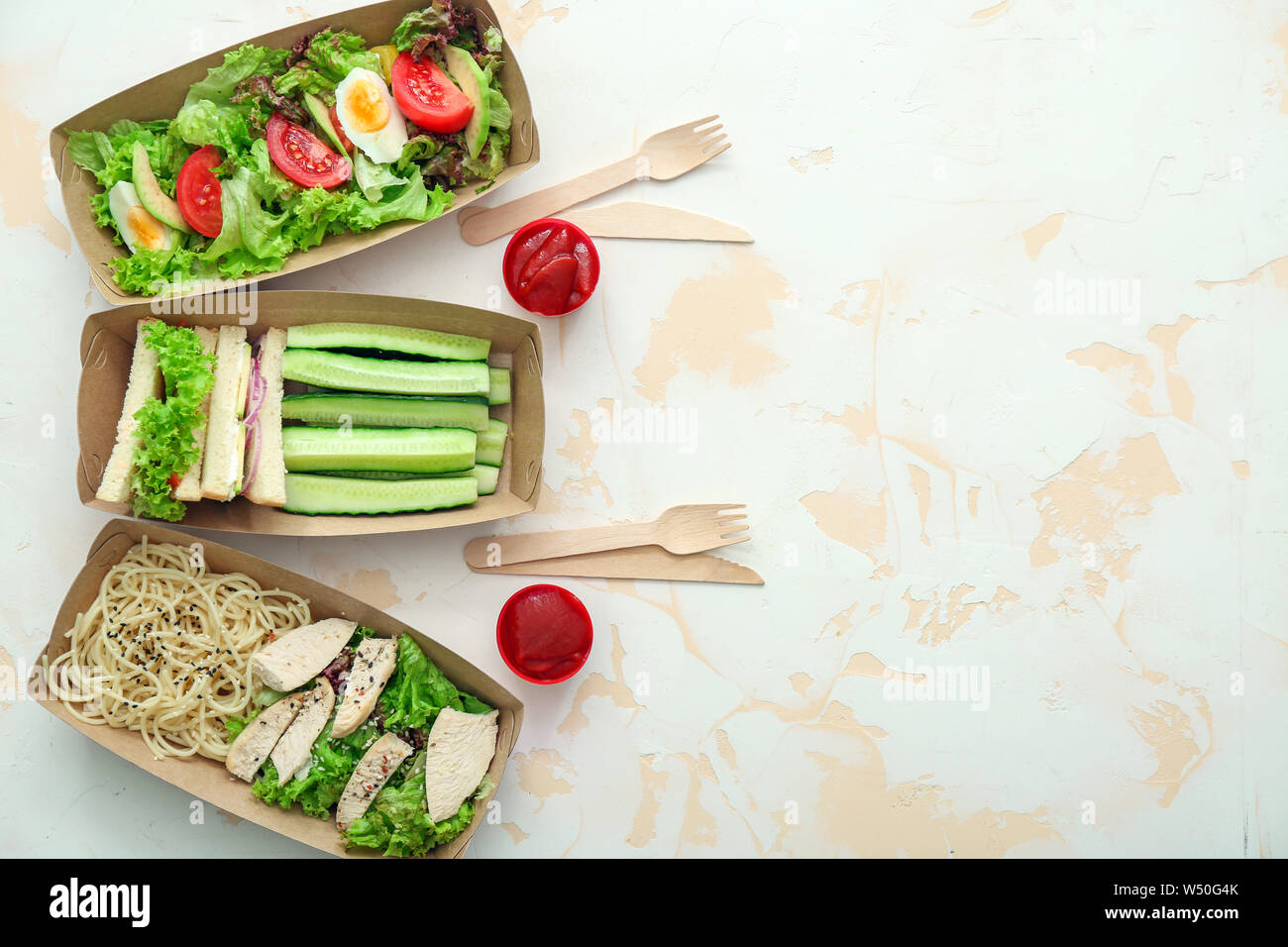 Paper boxes with delicious food on light background Stock Photo - Alamy