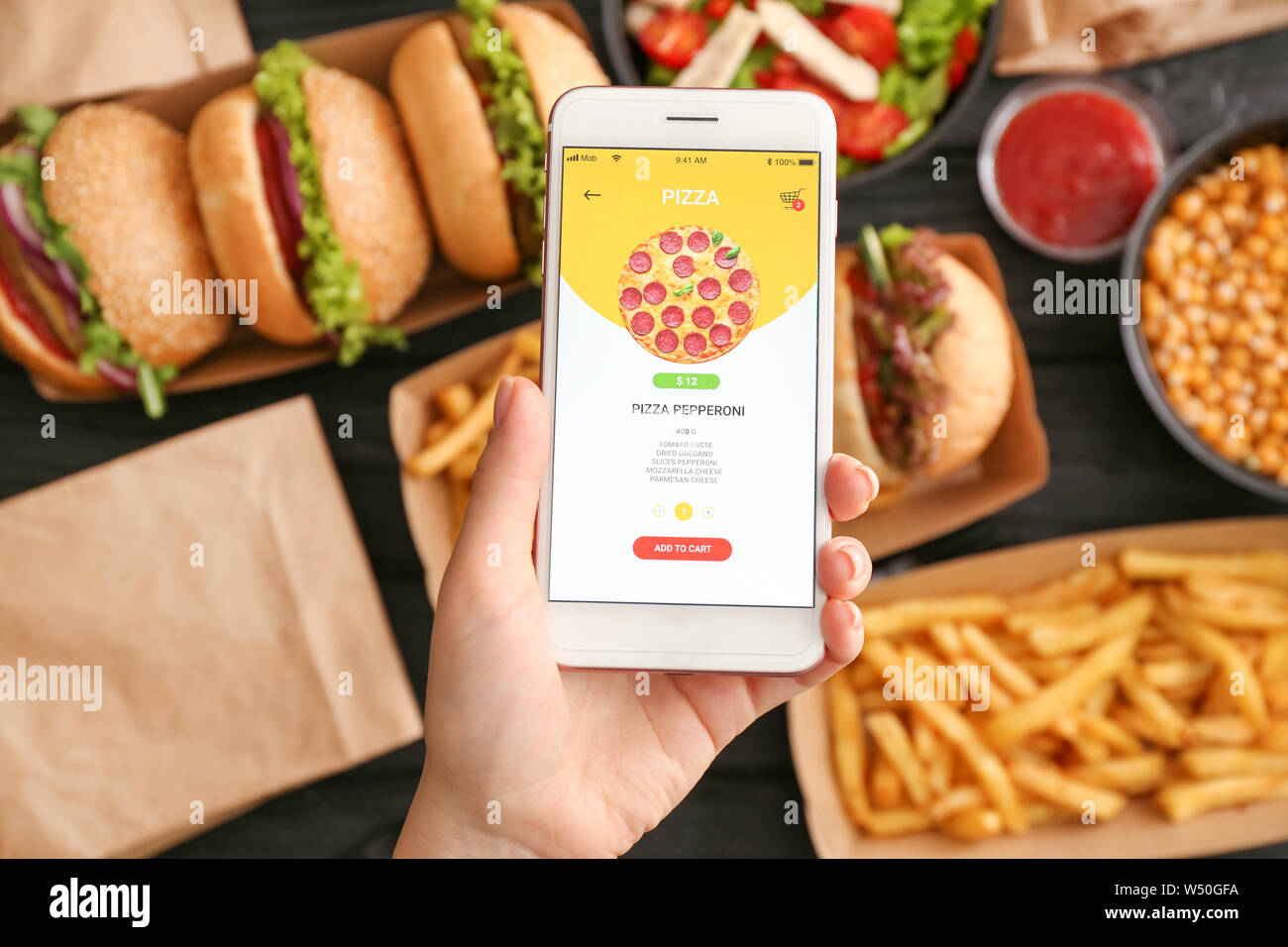 Woman with mobile phone ordering food online Stock Photo - Alamy
