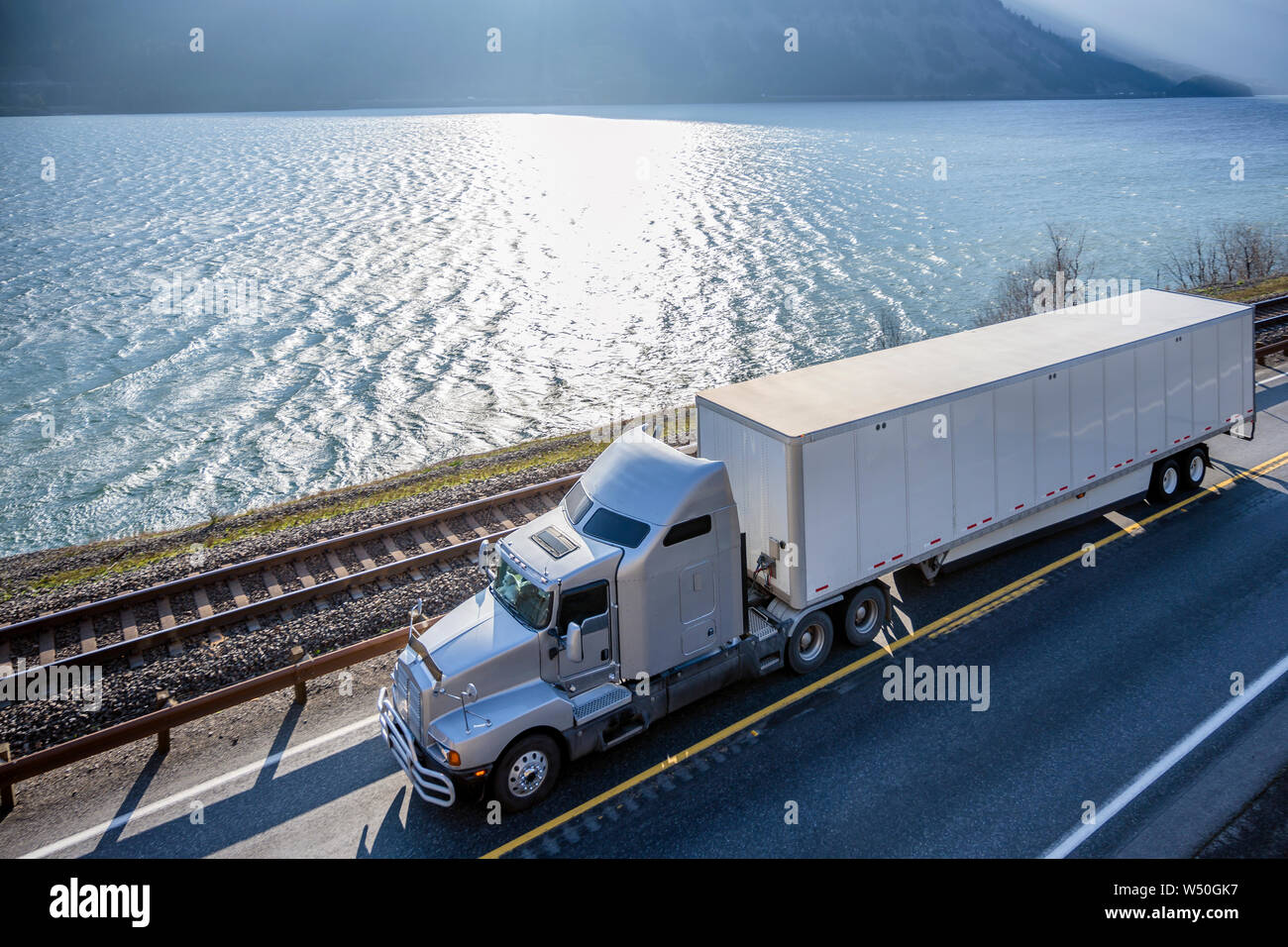 Big rig classic American powerful gray semi truck with dry van semi ...