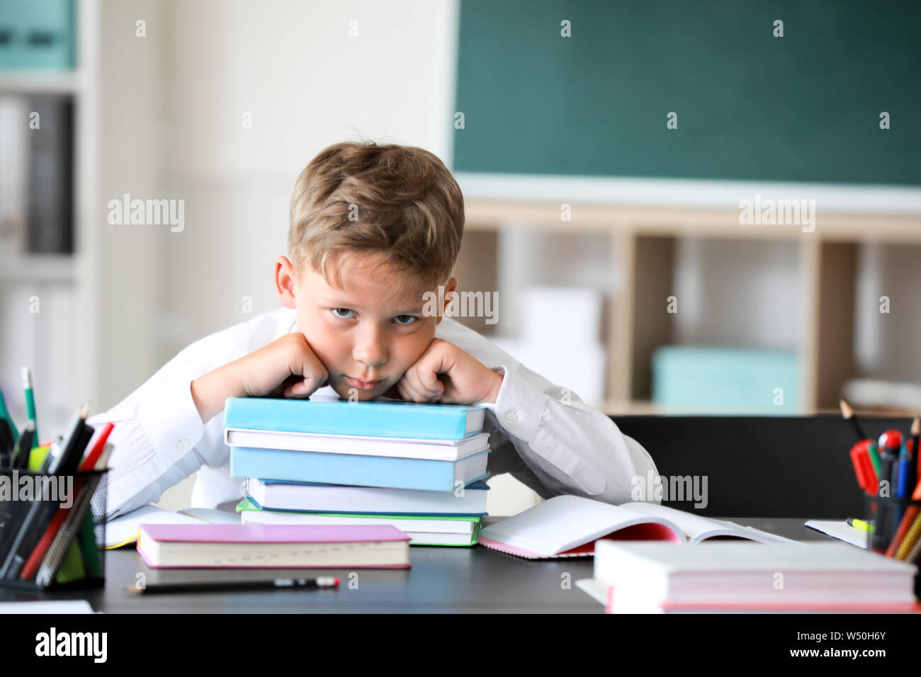 Annoyed little schoolboy in classroom Stock Photo - Alamy