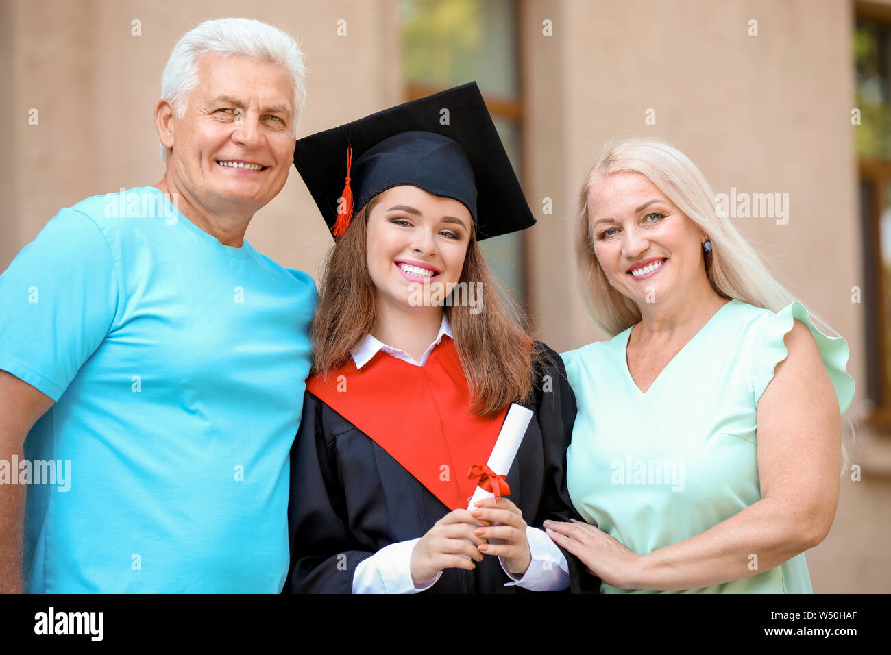 Happy young woman with her parents on graduation day Stock Photo - Alamy