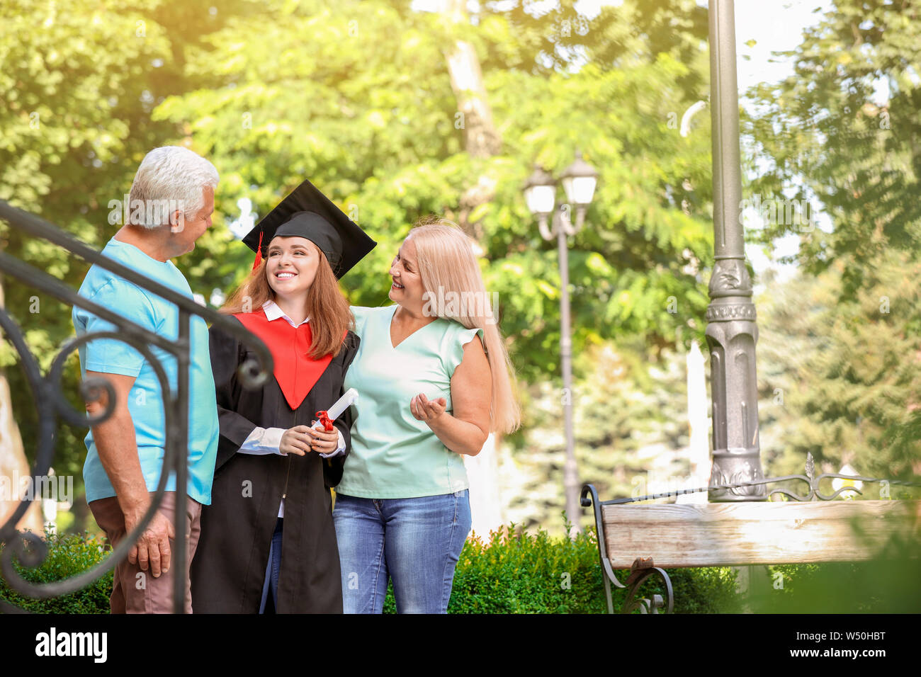 Happy young woman with her parents on graduation day Stock Photo - Alamy