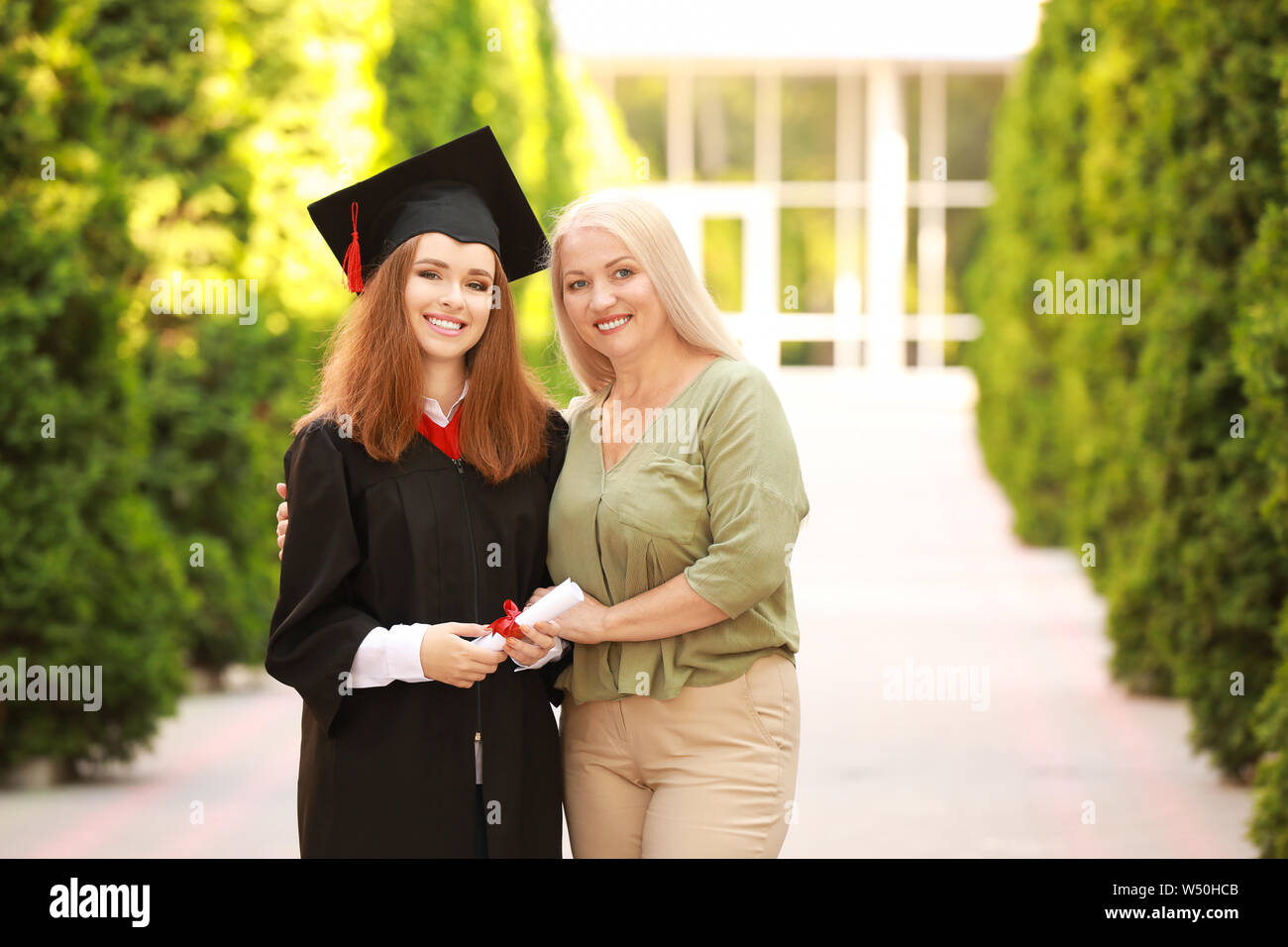 Happy young woman with her mother on graduation day Stock Photo - Alamy