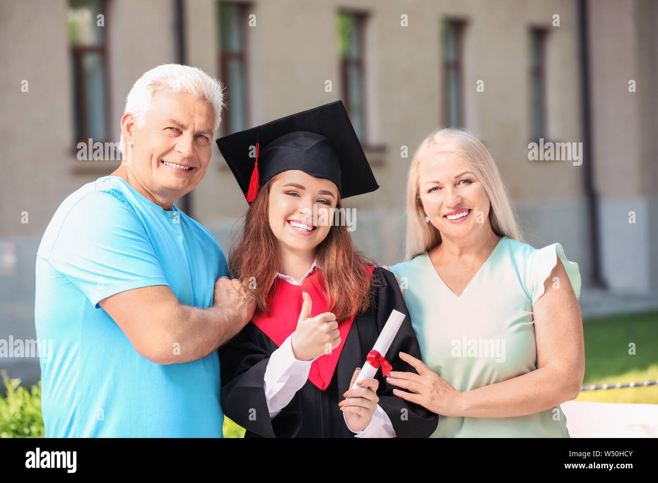 Happy young woman with her parents on graduation day Stock Photo - Alamy