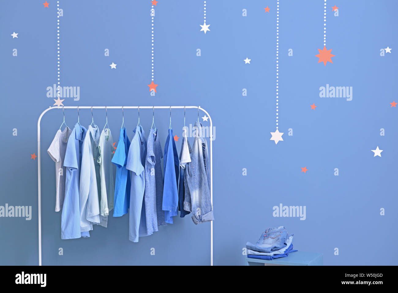 Rack with hanging clothes on color background Stock Photo - Alamy