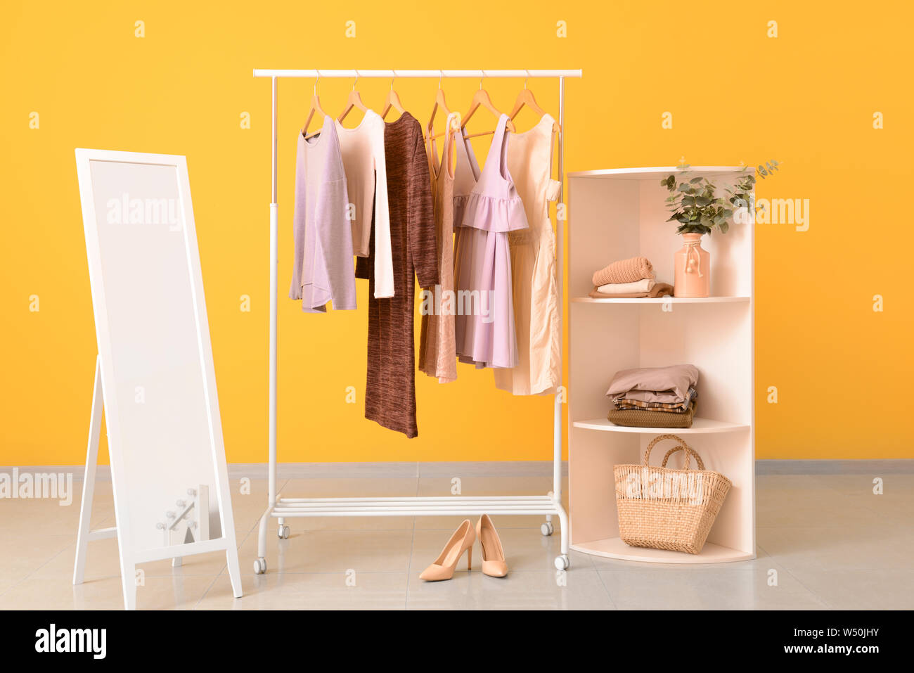 Rack with hanging clothes in interior of dressing room Stock Photo - Alamy