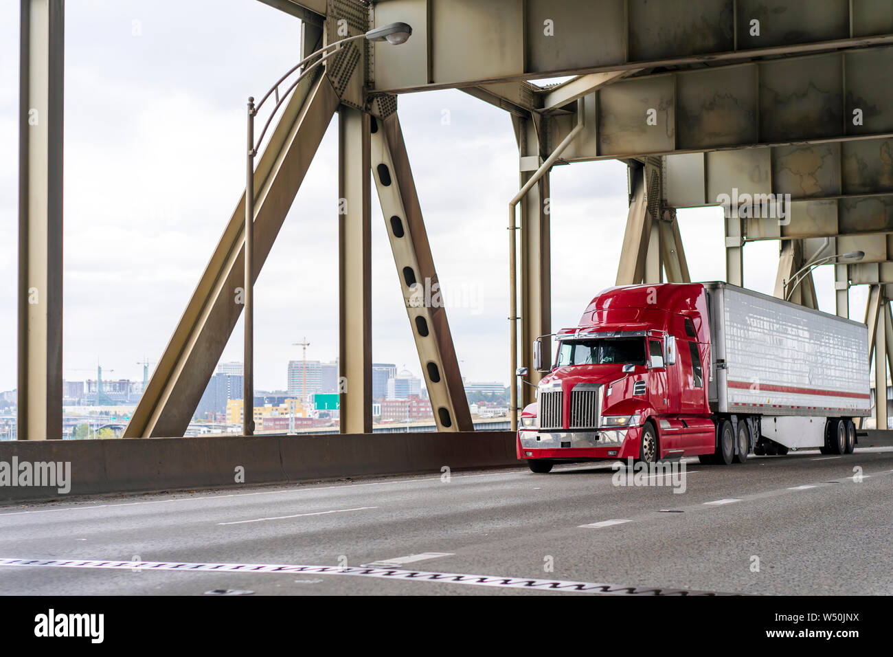 Red big rig long haul semi truck transporting commercial cargo in ...