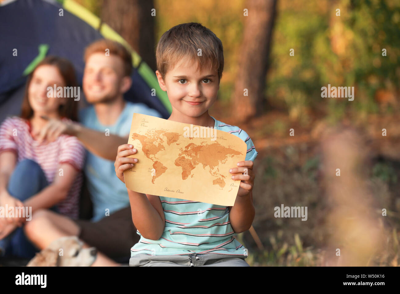 Little boy with world map in camp Stock Photo - Alamy