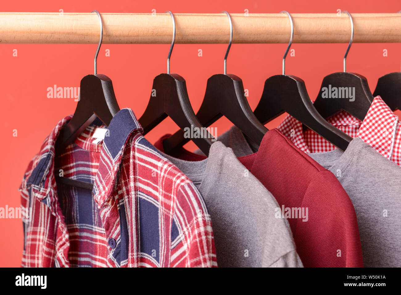 Rack with hanging clothes on color background Stock Photo - Alamy