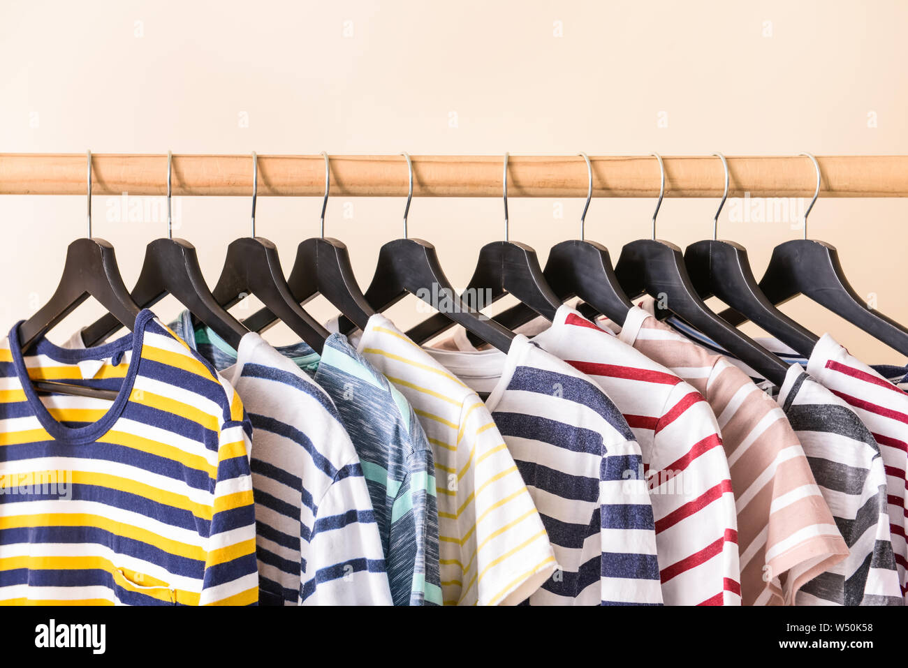 Rack with hanging clothes on color background Stock Photo - Alamy