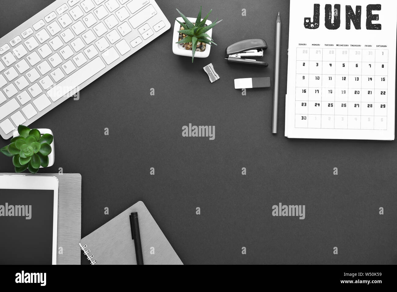 Composition with stationery, calendar and computer keyboard on dark ...