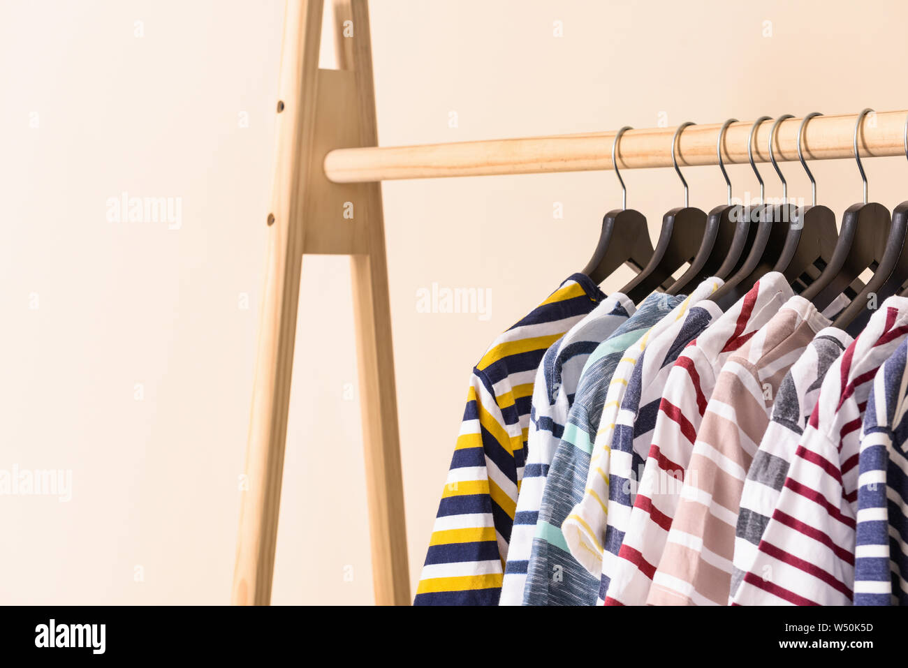 Rack with hanging clothes on color background Stock Photo - Alamy